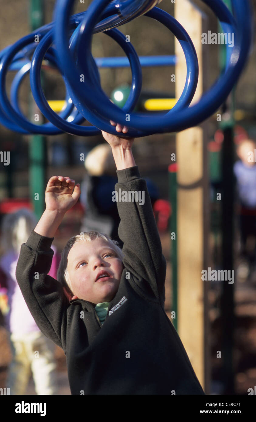 Child on trapeze rings in park Stock Photo - Alamy