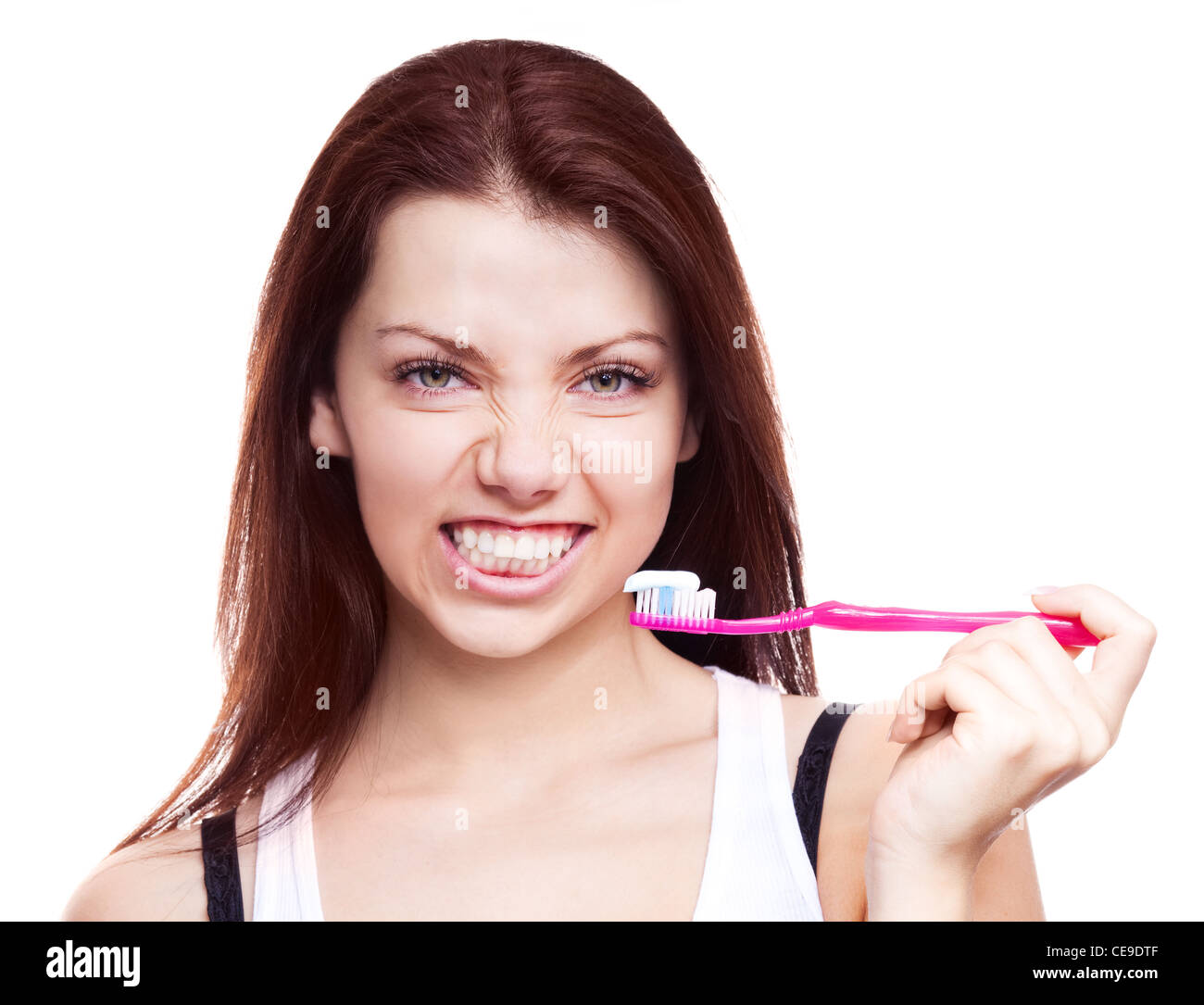 humorous portrait of a pretty woman brushing teeth and making faces ...