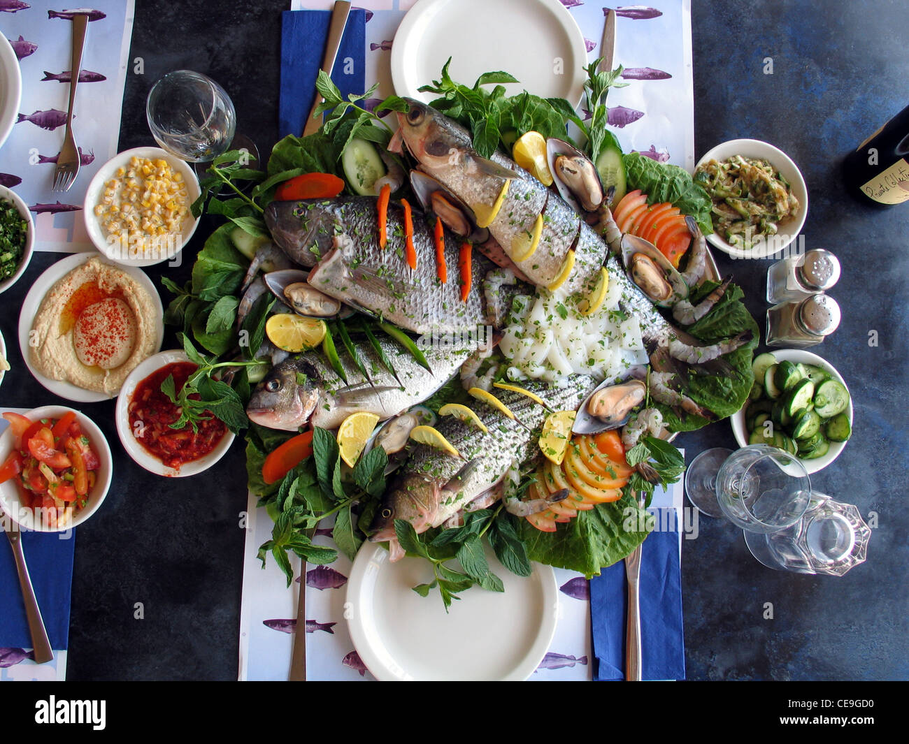 Fresh Flathead grey mullet fish accompanied by assorted salads, served ...