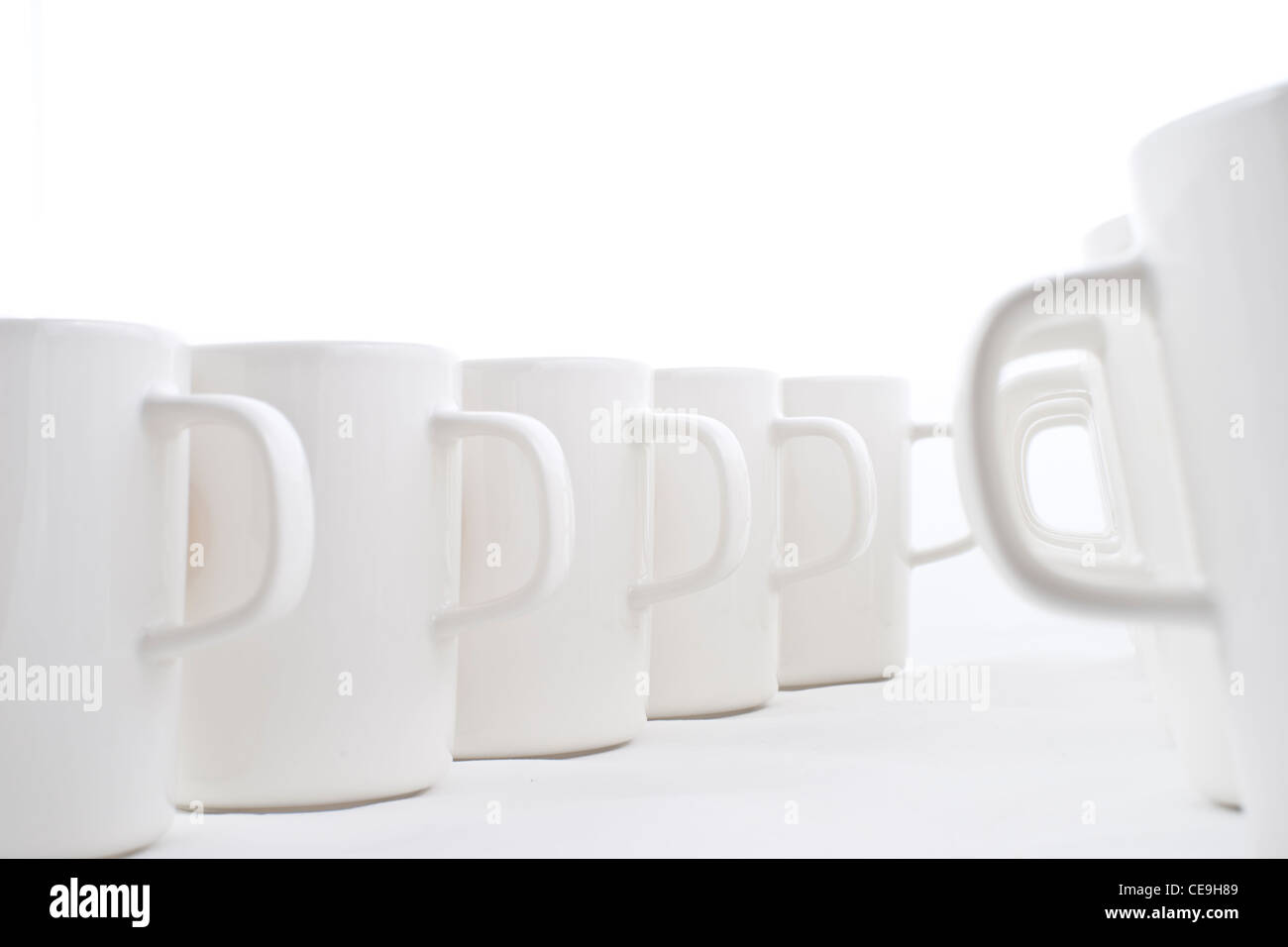 Line of white cups, on white background Stock Photo - Alamy