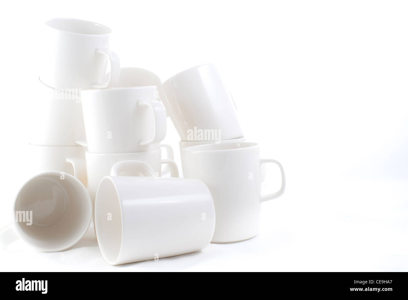 Many stacked of white cups on white background Stock Photo - Alamy