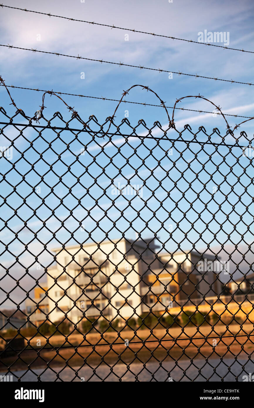 Looking through barb wired fence at out of focus buildings in the ...