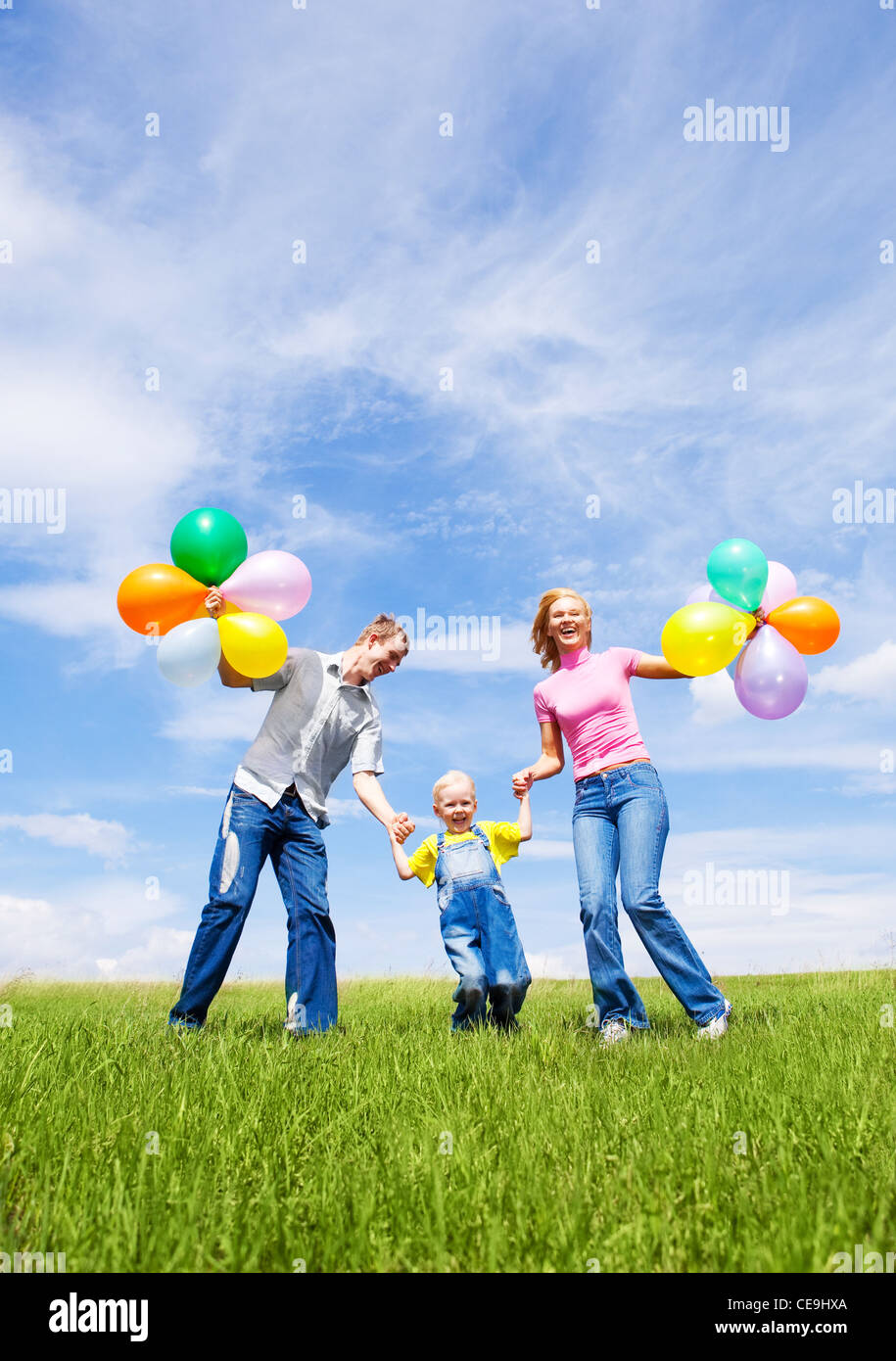 happy family with balloons running outdoor on a warm summer day Stock ...