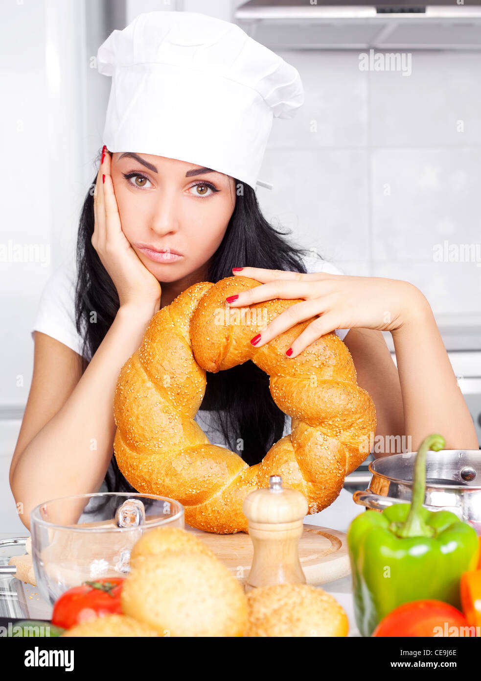 tired and bored housewife with bread and vegetables in the kitchen at ...
