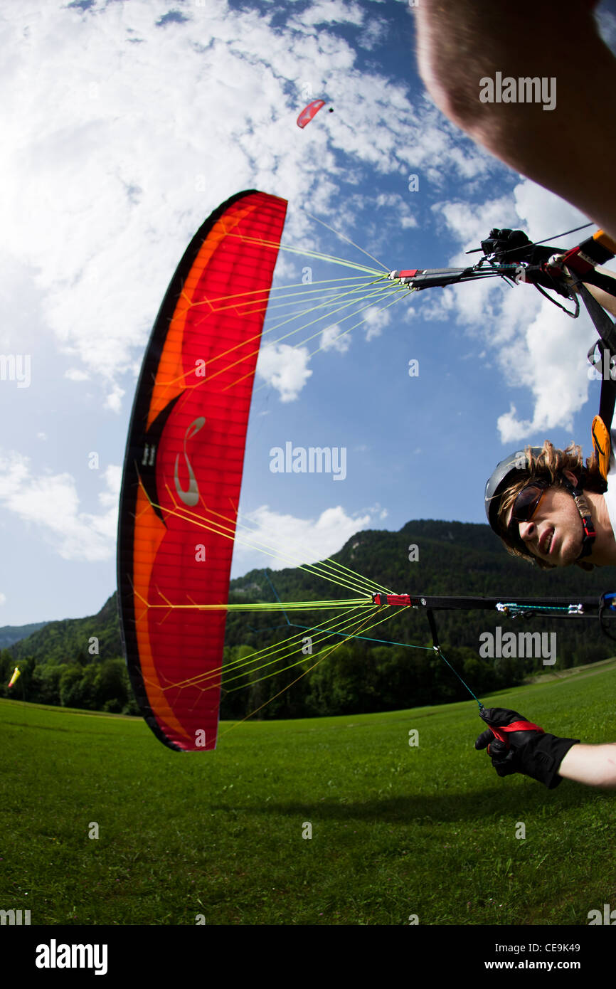 Acro paraglider pilot performing tricks next to the ground in ...