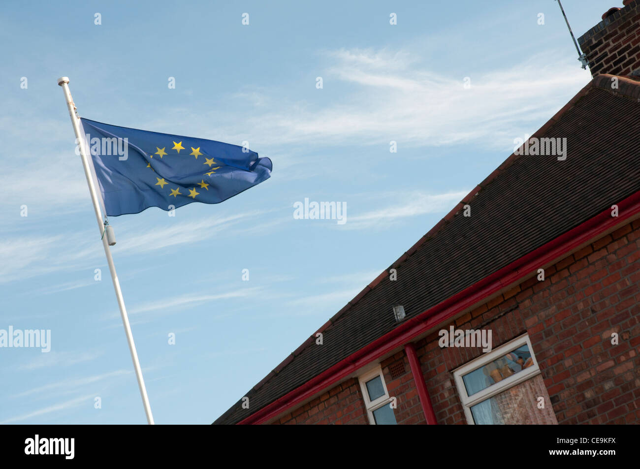 A European Union flag flying from a flagpole in a typical English ...