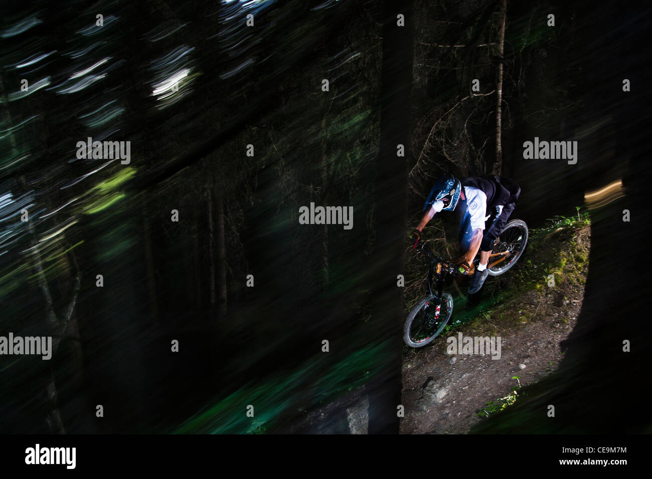 Mountainbiker riding downhill in the forest trails of Lauterbrunnen ...