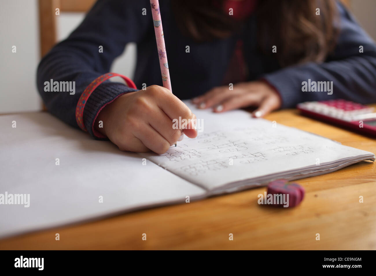 Young girl completing her homework alone Stock Photo - Alamy