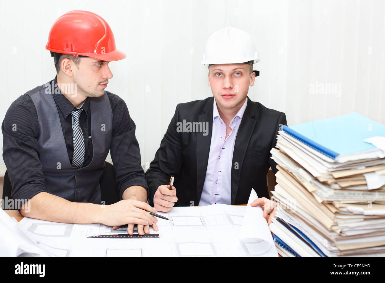 Architect and construction engineer discussing plan in office room ...
