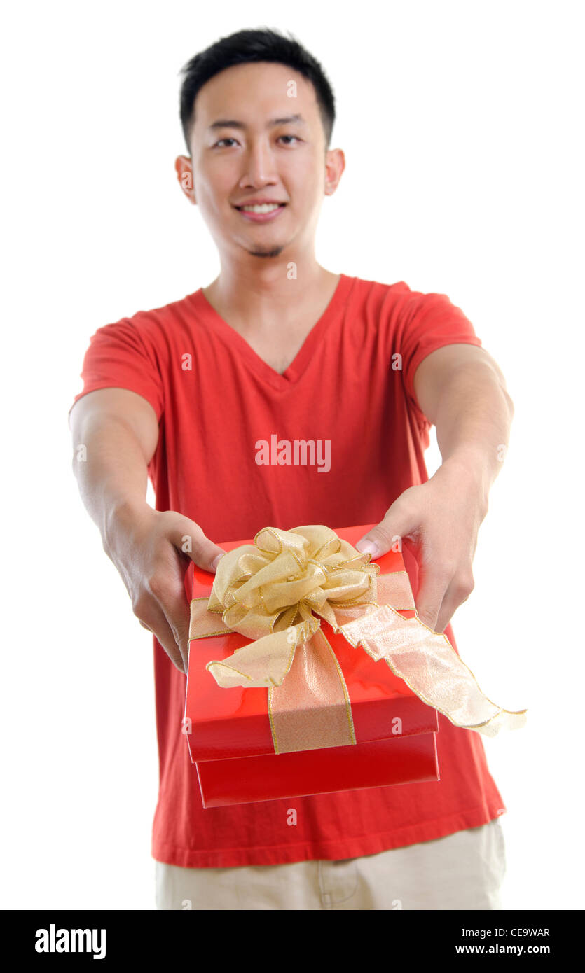 Asian young man giving a gift box on white background Stock Photo - Alamy