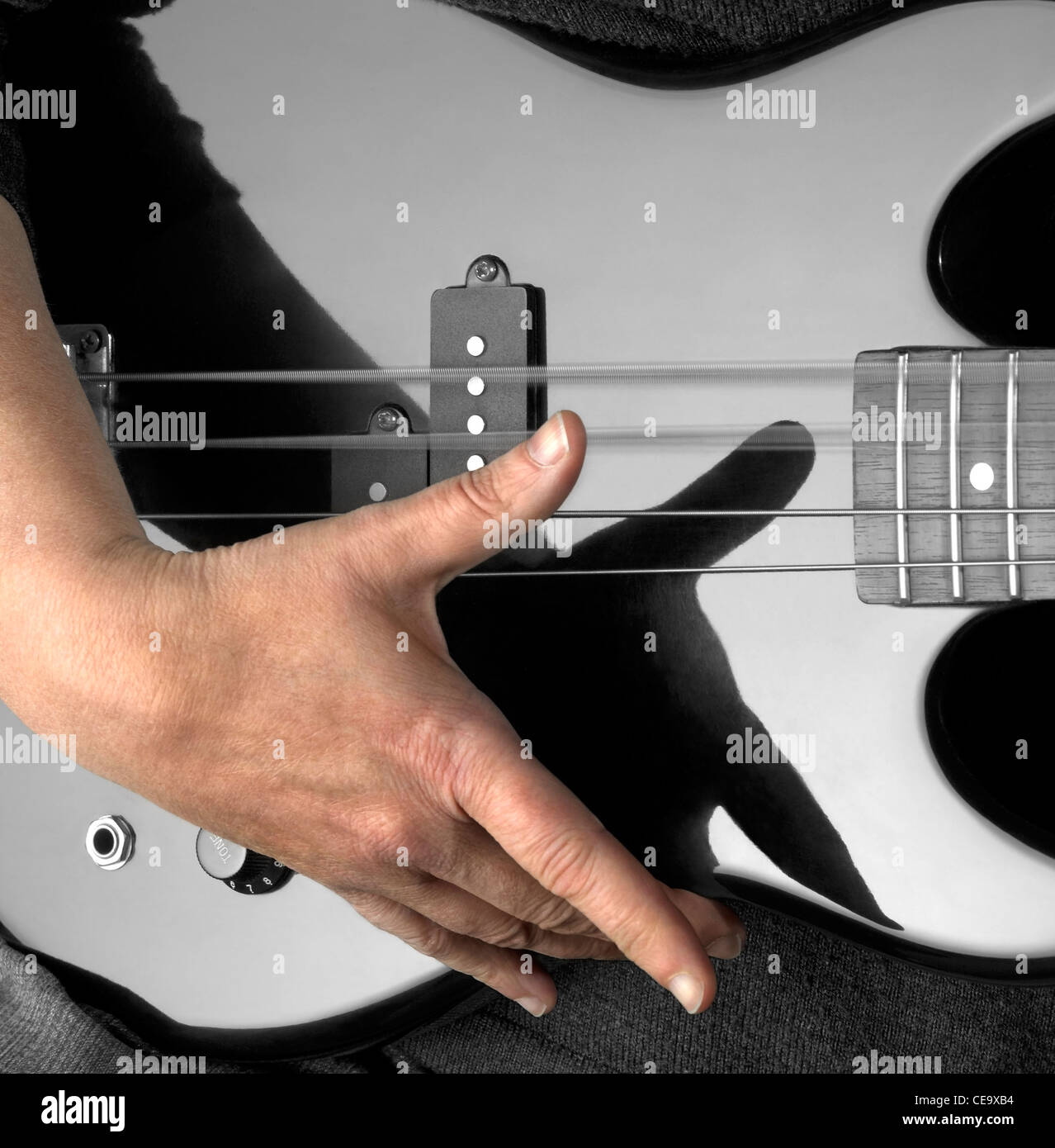 female hand on the detail of a black bass guitar in dark back Stock ...