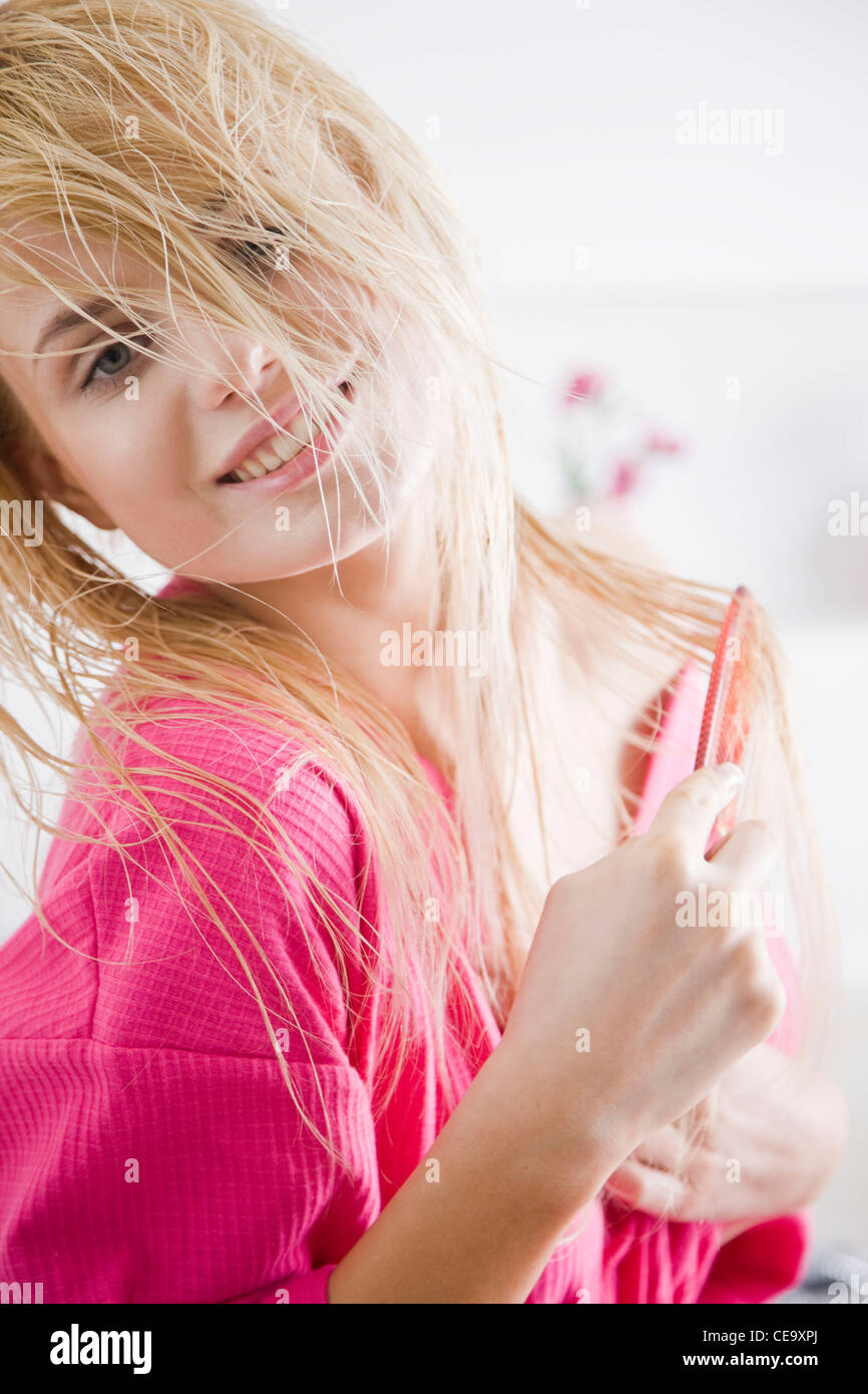 Young blonde woman combing hair hi-res stock photography and images - Alamy
