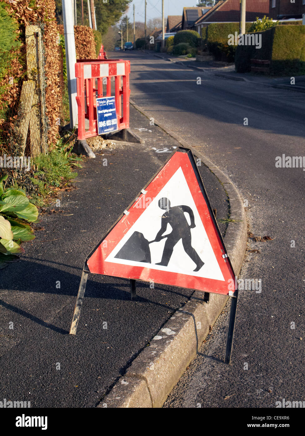 Men at work warning road sign with barriers behind indicating work site ...