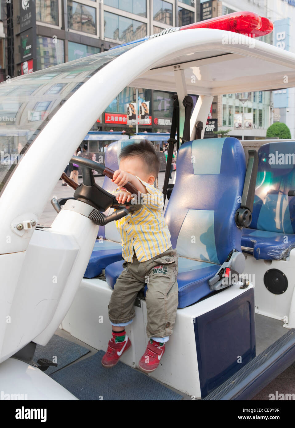 Child pretending to drive police car; Shanghai; China Stock Photo - Alamy