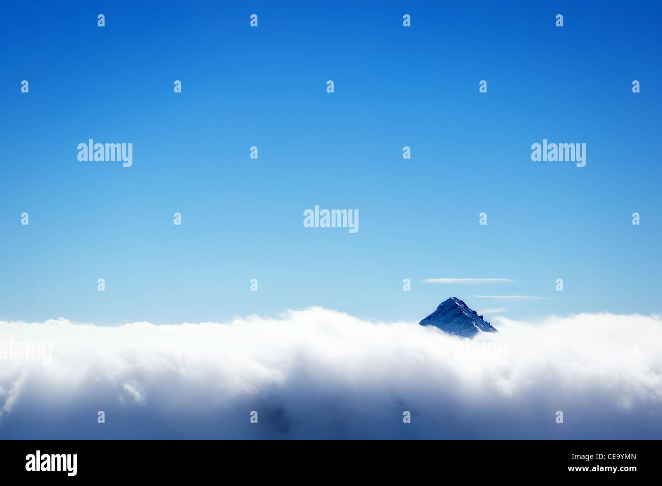 Winter landscape - snowed mountain's top over white clouds cover and ...