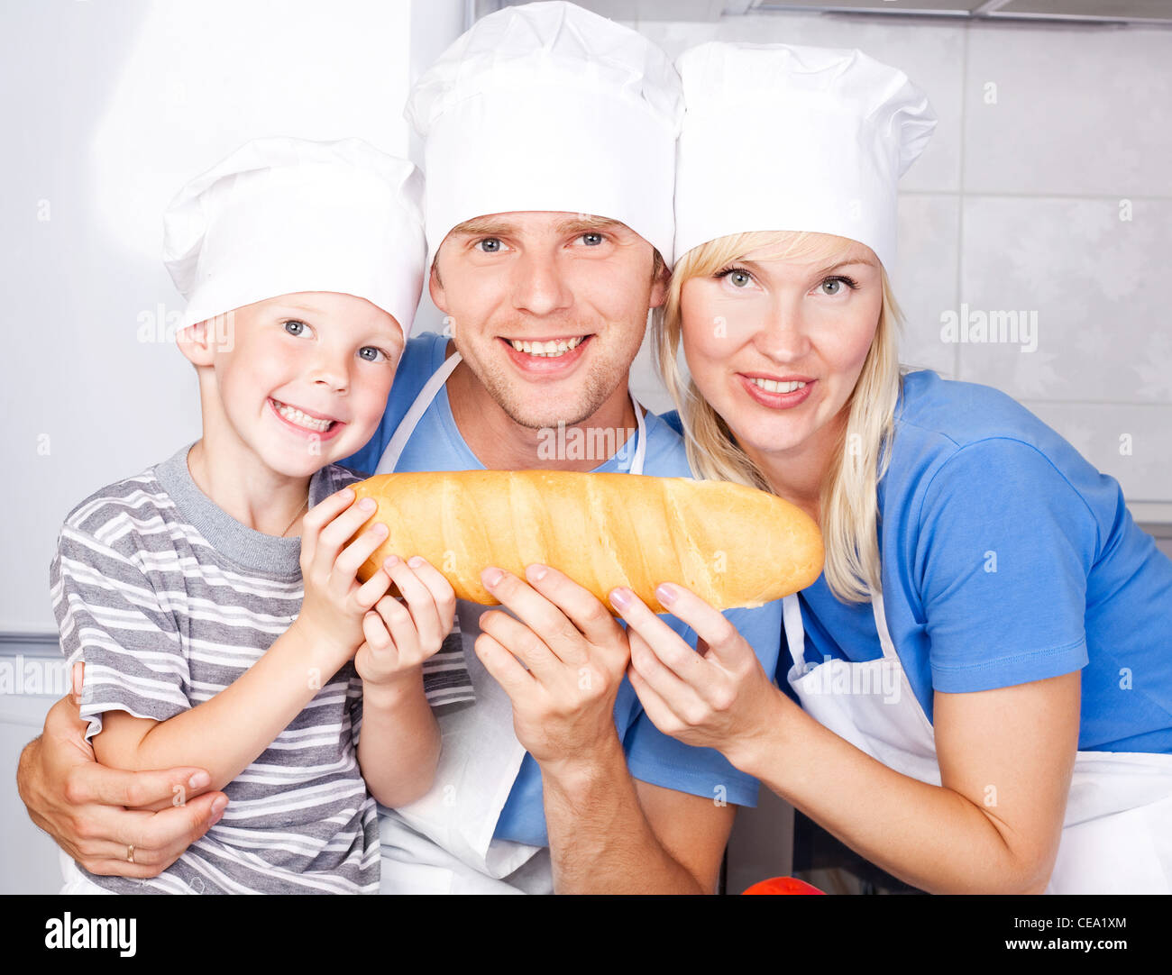 young family; father, mother and their five year old son eating bread ...