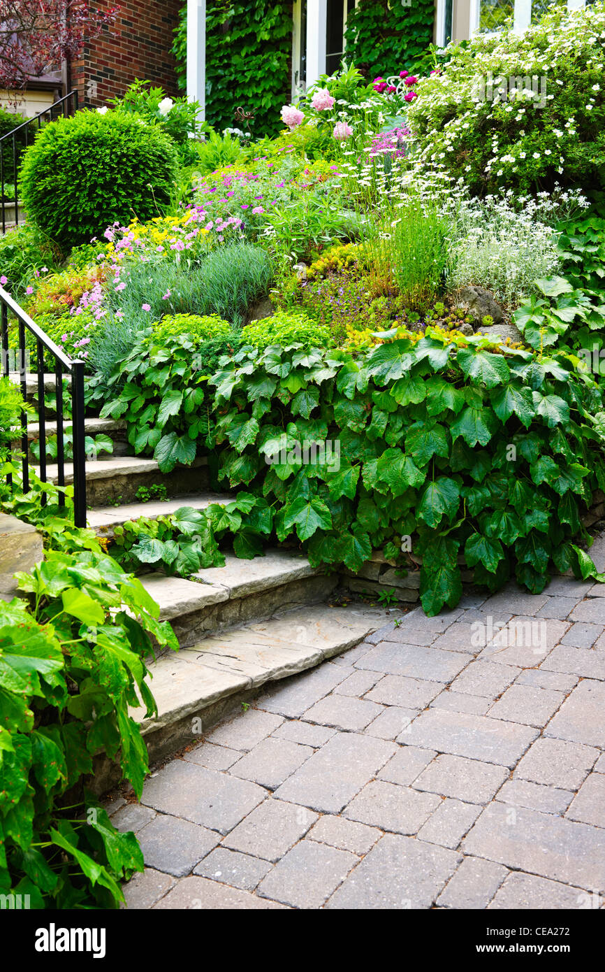 Landscaped garden path with natural stone steps and metal railing Stock ...