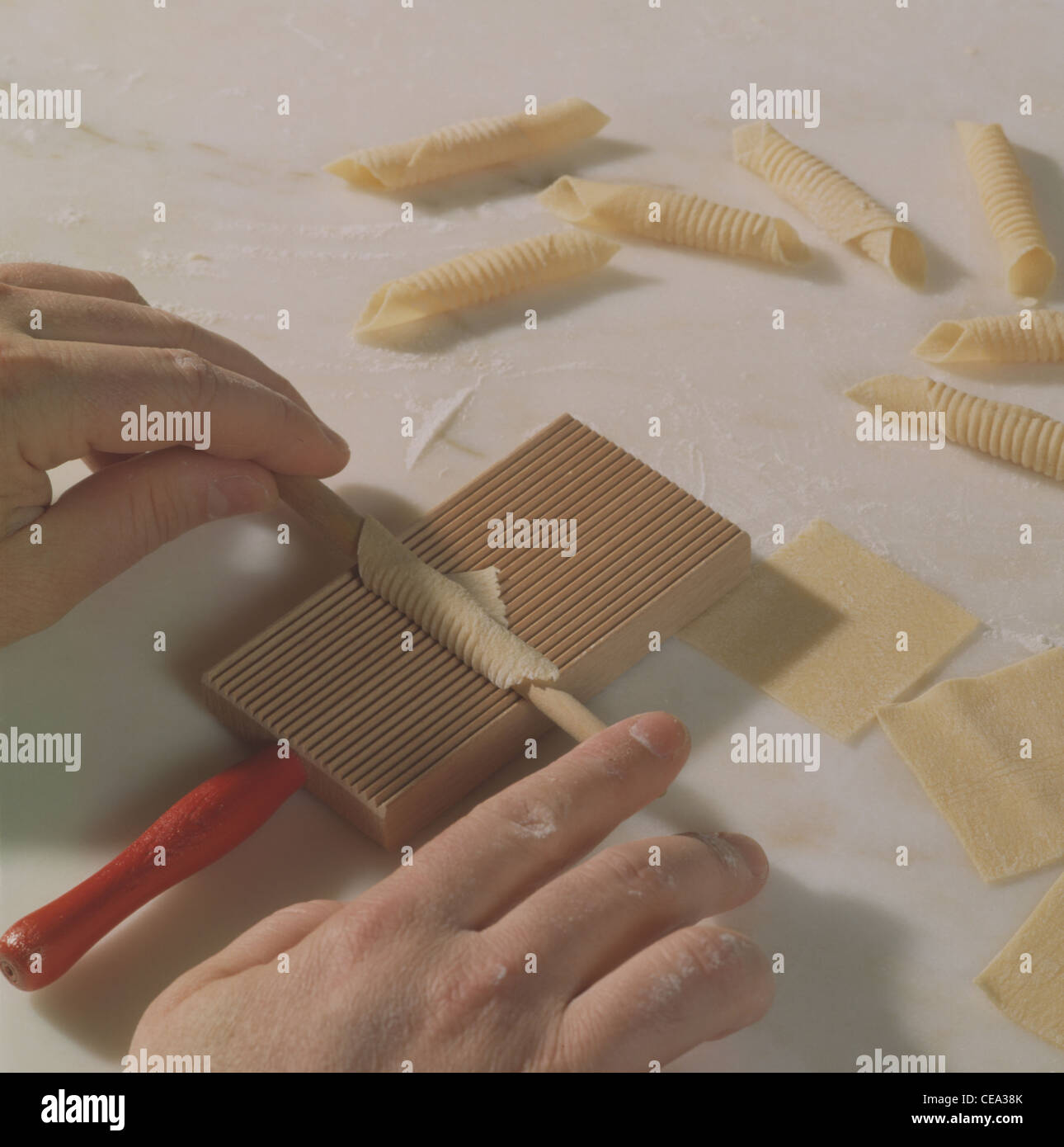 Step self - made pasta: roll garganelli on wood stick over riffle board ...