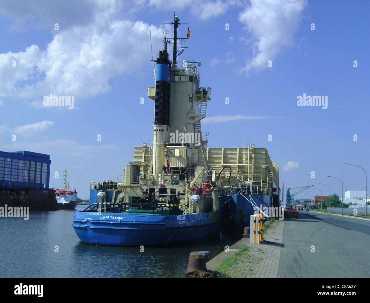 The pusher tug Mega is connected with a barge, providing assistance ...