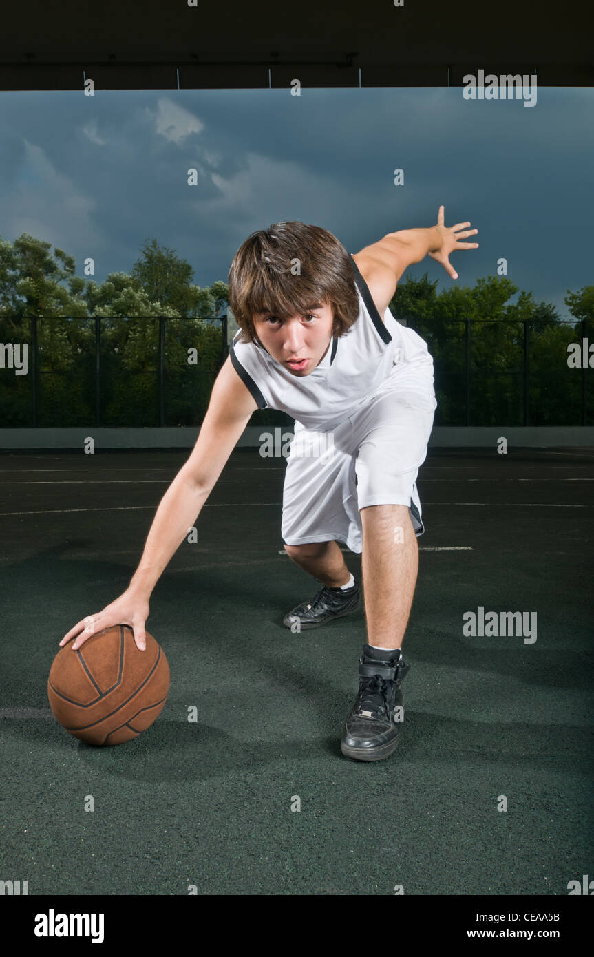 Teenage boy with basketball at the street playground Stock Photo - Alamy