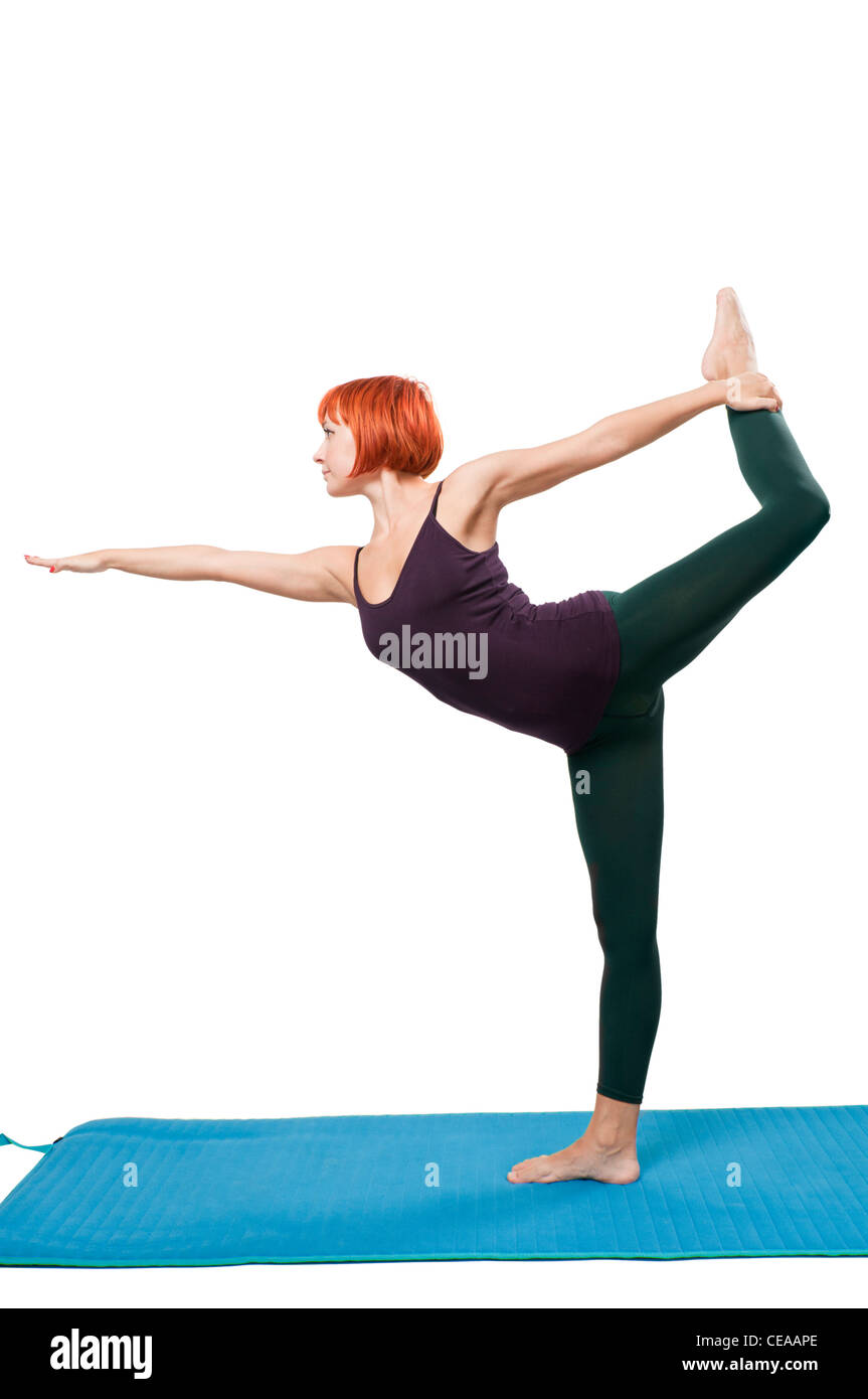 Red girl standing in yogatic asana on one leg Stock Photo - Alamy