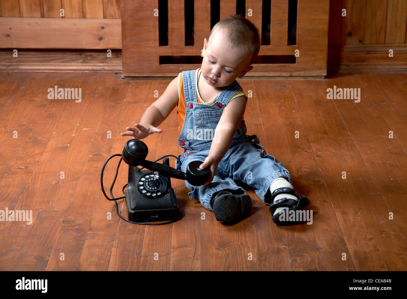 The little boy plays old phone sitting on a floor Stock Photo - Alamy