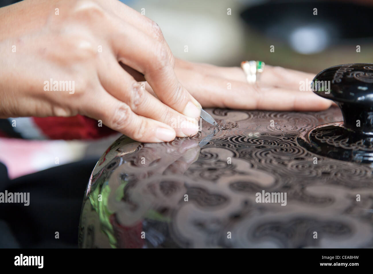 Lacquer manufacture in Bagan, Burma. Woman is engraving by lancet ...