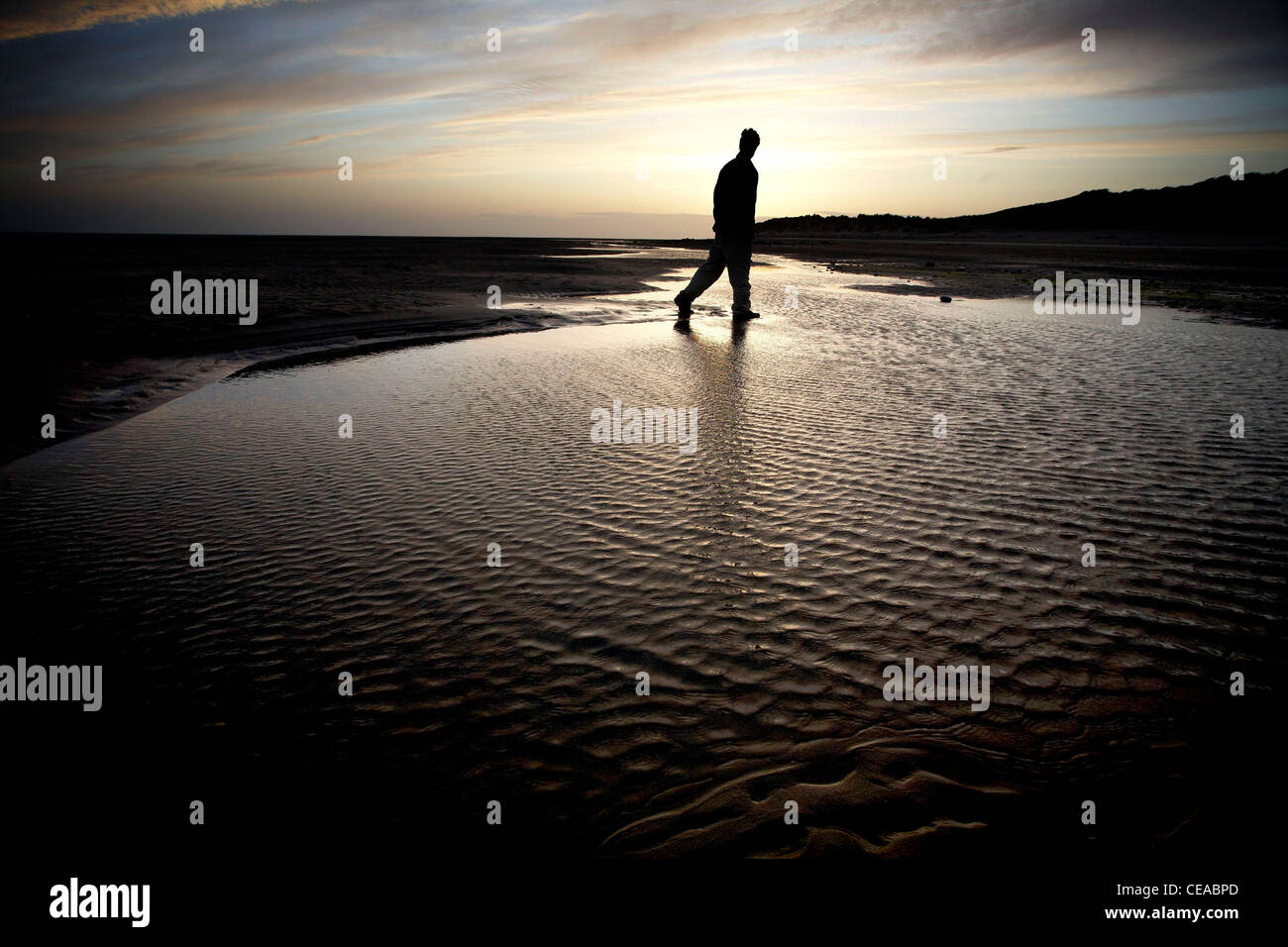 Walking through sea water on a beach in Barmouth Stock Photo - Alamy