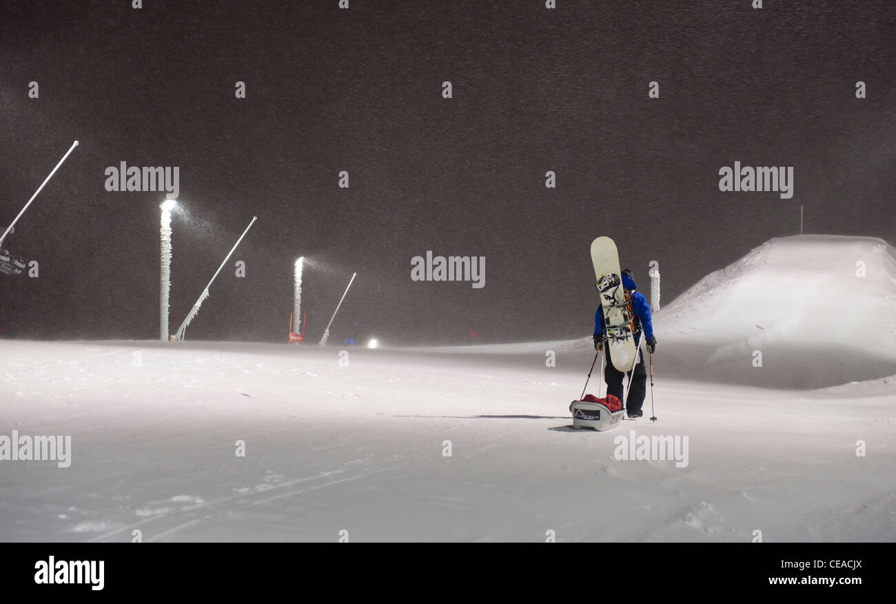A nowboarder exercising sledge pulling up the slope of Pyhätunturi ...