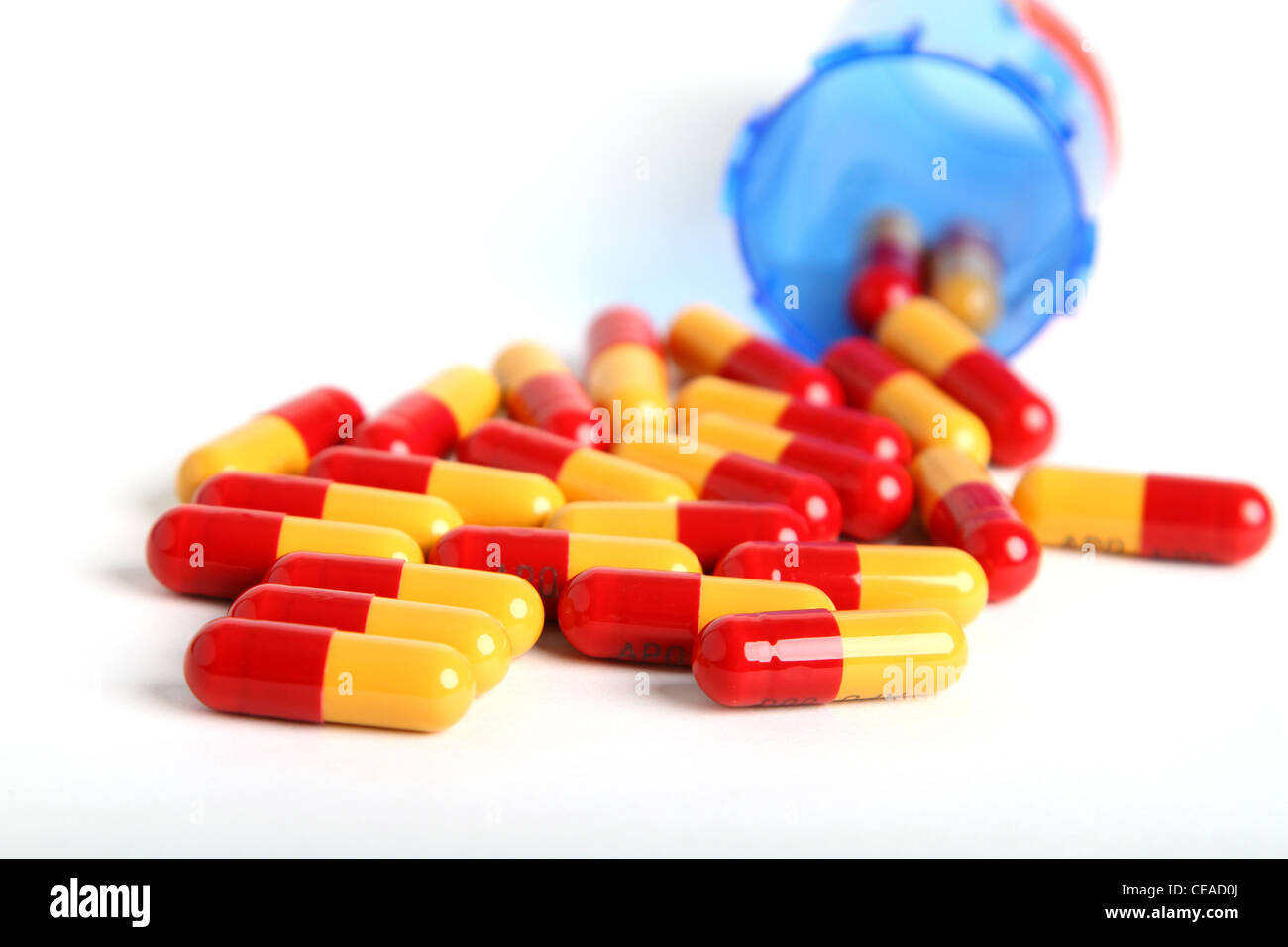 Capsules spill out from a blue pill bottle Stock Photo - Alamy