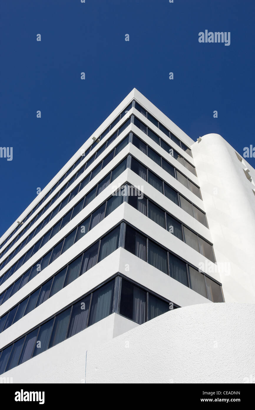 A tall white building rising into a deep blue sky Stock Photo - Alamy