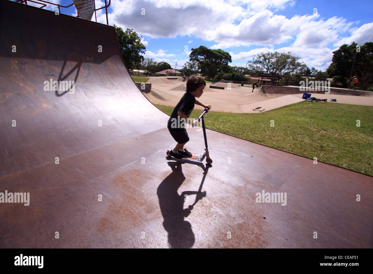 A young boy drops in on his scooter a metal half pipe at the Atherton ...