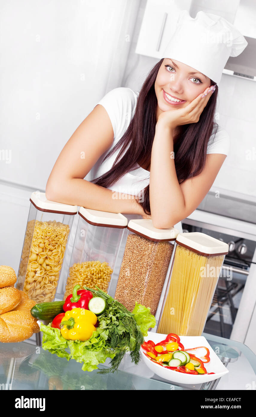 beautiful young cook with pasta and vegetables in the kitchen Stock ...