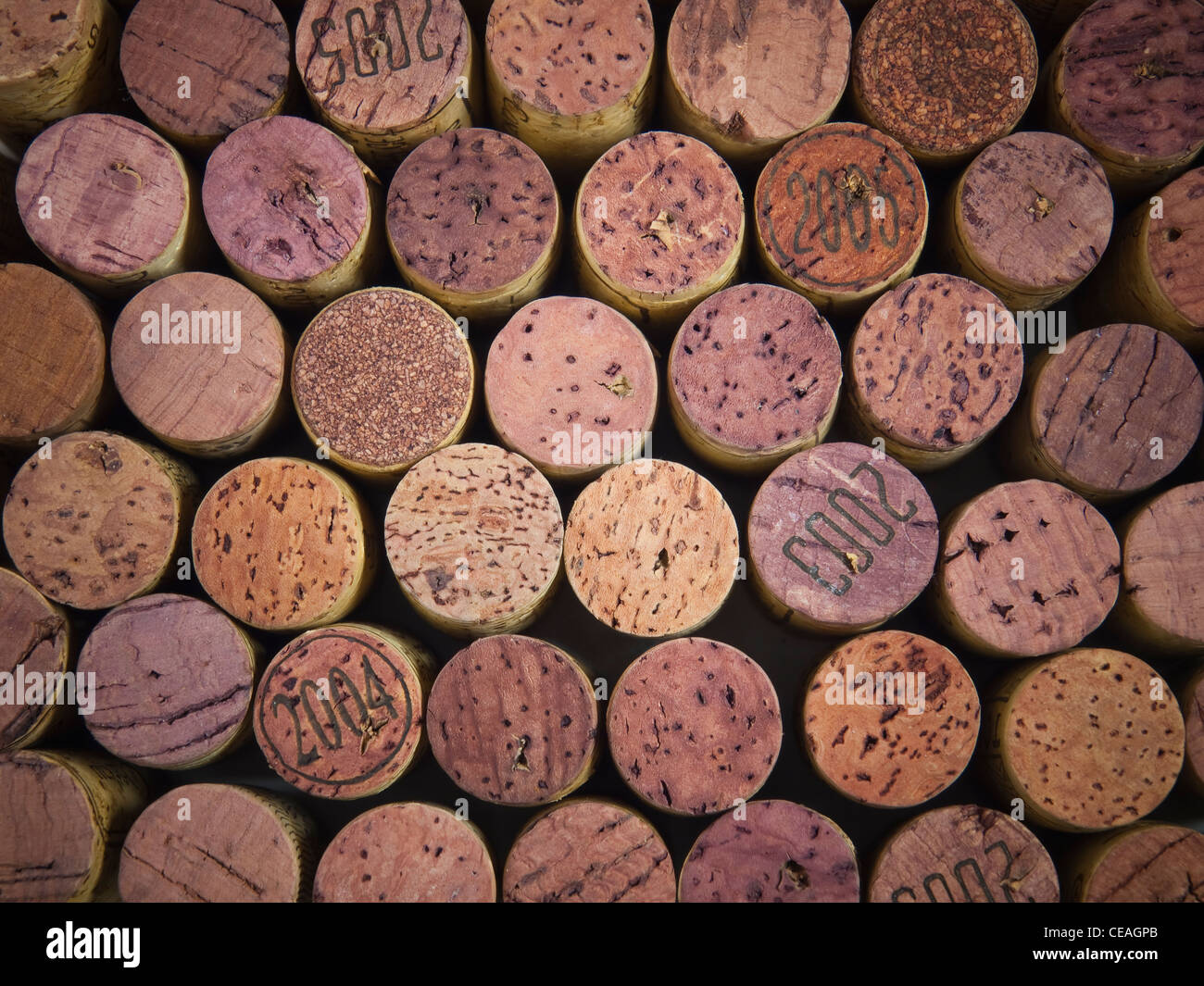 A collection of used wine corks, several with the vintage year visible ...