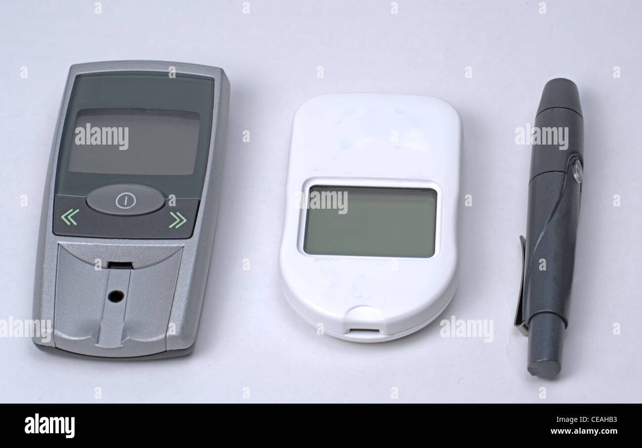 Two types of glucometers and a pricker over white background-useful ...