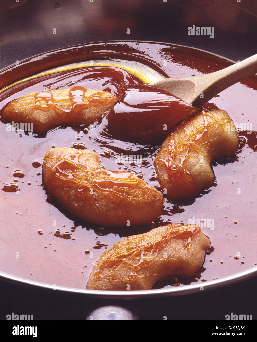 Step: Coat deep fried pineapples with caramel threads Stock Photo - Alamy