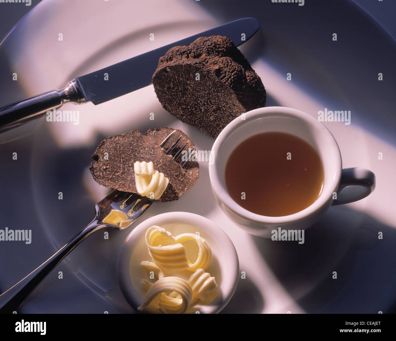 Still: Black truffle, butter curls, beef tea in a cup Stock Photo - Alamy