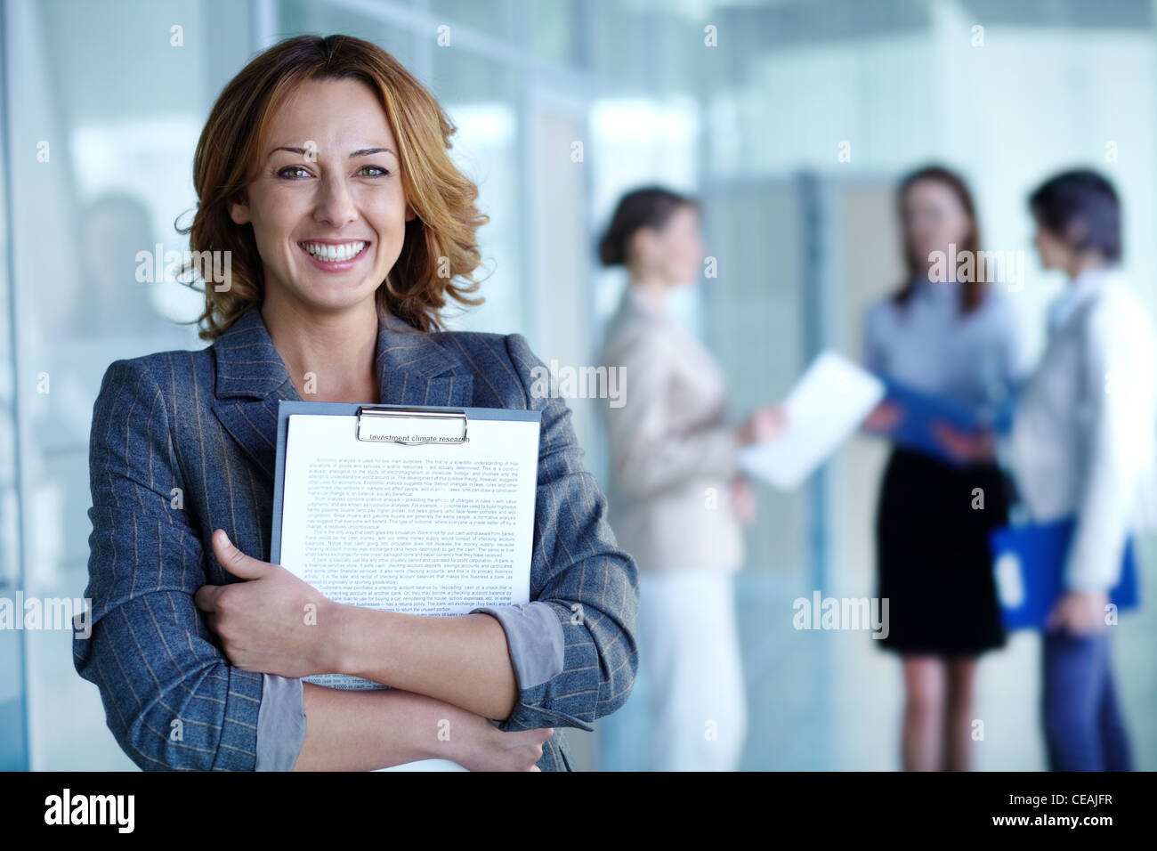 Image of pretty businesswoman with document looking at camera in ...