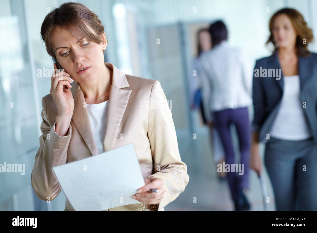 Image of agent reading document while speaking on the phone in working ...