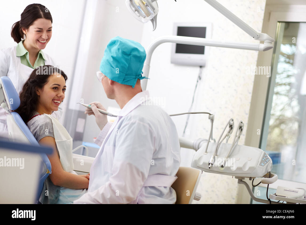 Cheerful patient receiving dental care from a friendly doctor and his ...