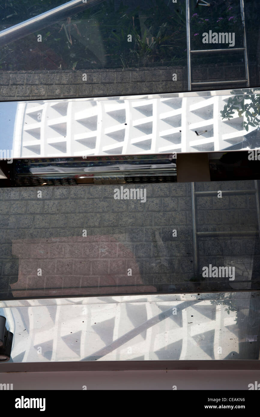 Tower block reflected in the glass mirror structure of another building ...