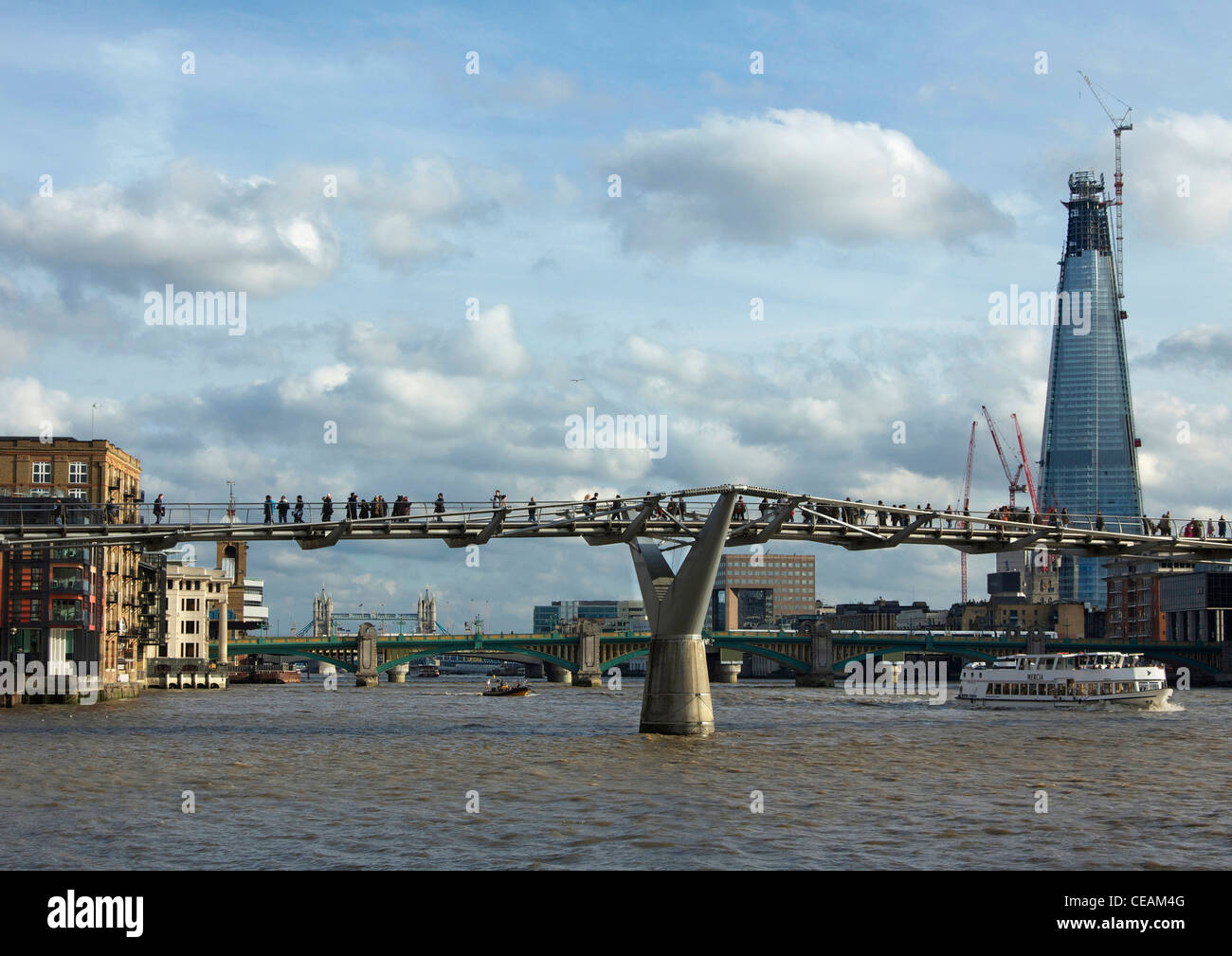 People on the Millenium Bridge, London England, with Tower Bridge and ...