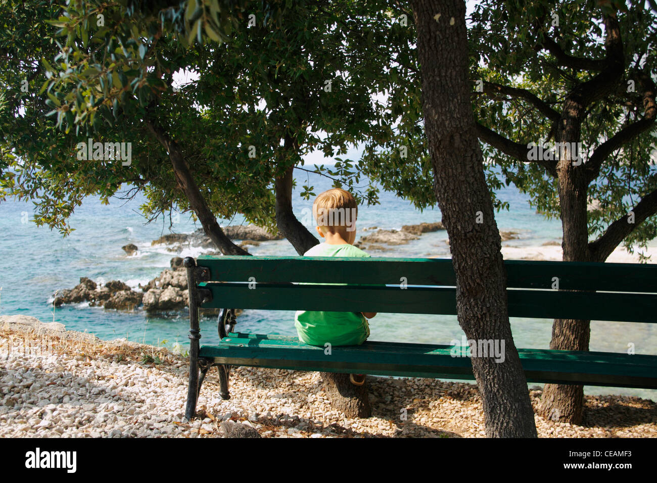 Boy sitting on a bench in Dingac Borak village, Peljesac peninsula ...
