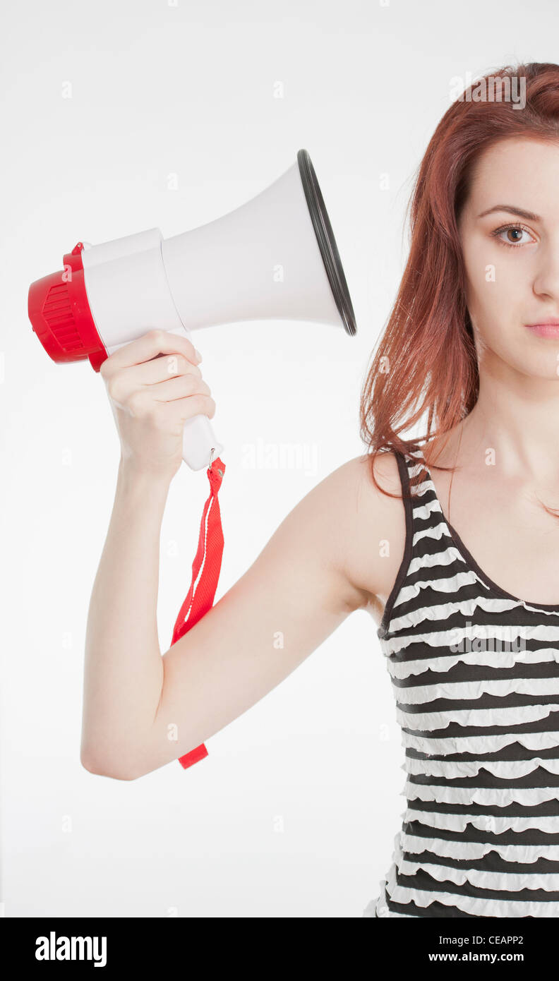 Young female holding a megaphone by her ear Stock Photo - Alamy