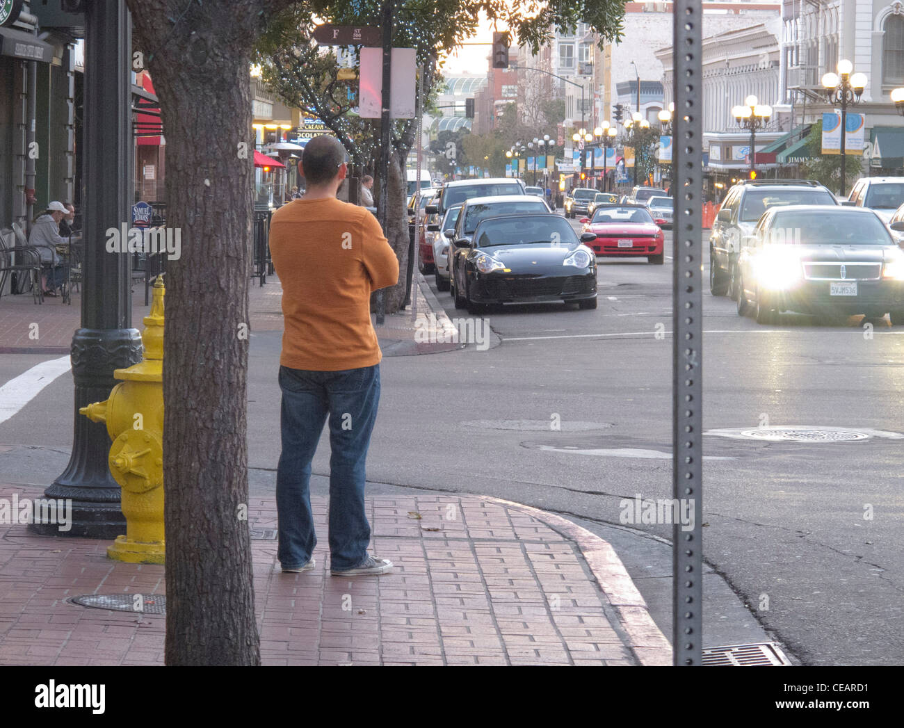young man standing on a street corner on fifth avenue in san diego ...