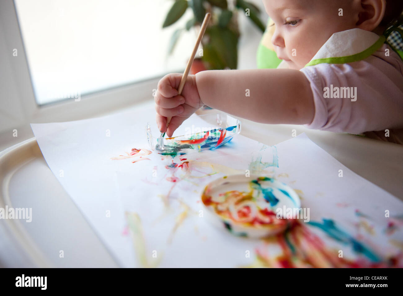 Little female baby painting with colorful paints Stock Photo - Alamy