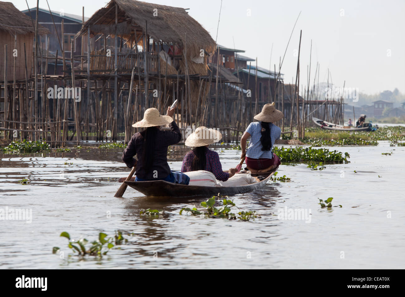 Tribal people on Inle lake are daily paddling their floating boats from ...