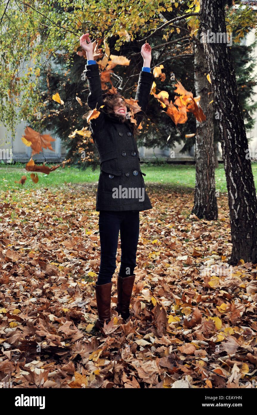 Portrait happy woman throwing autumn leaves air hi-res stock ...