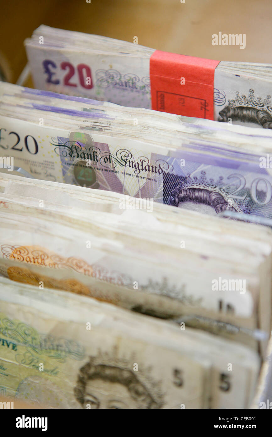 Five, ten and twenty pound notes stacked in a container Stock Photo - Alamy