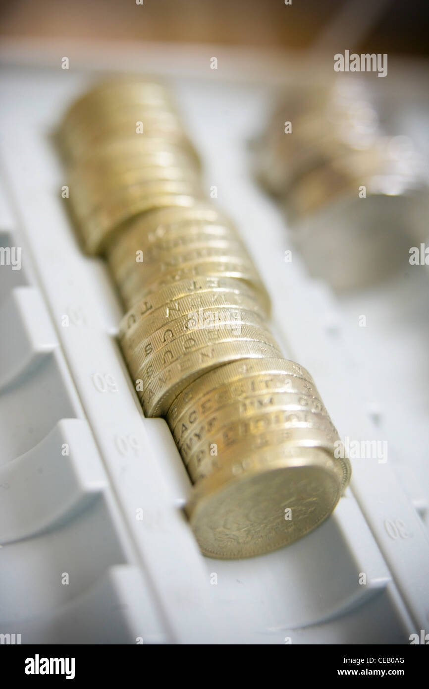 A stack of one pound coins in a container Stock Photo - Alamy